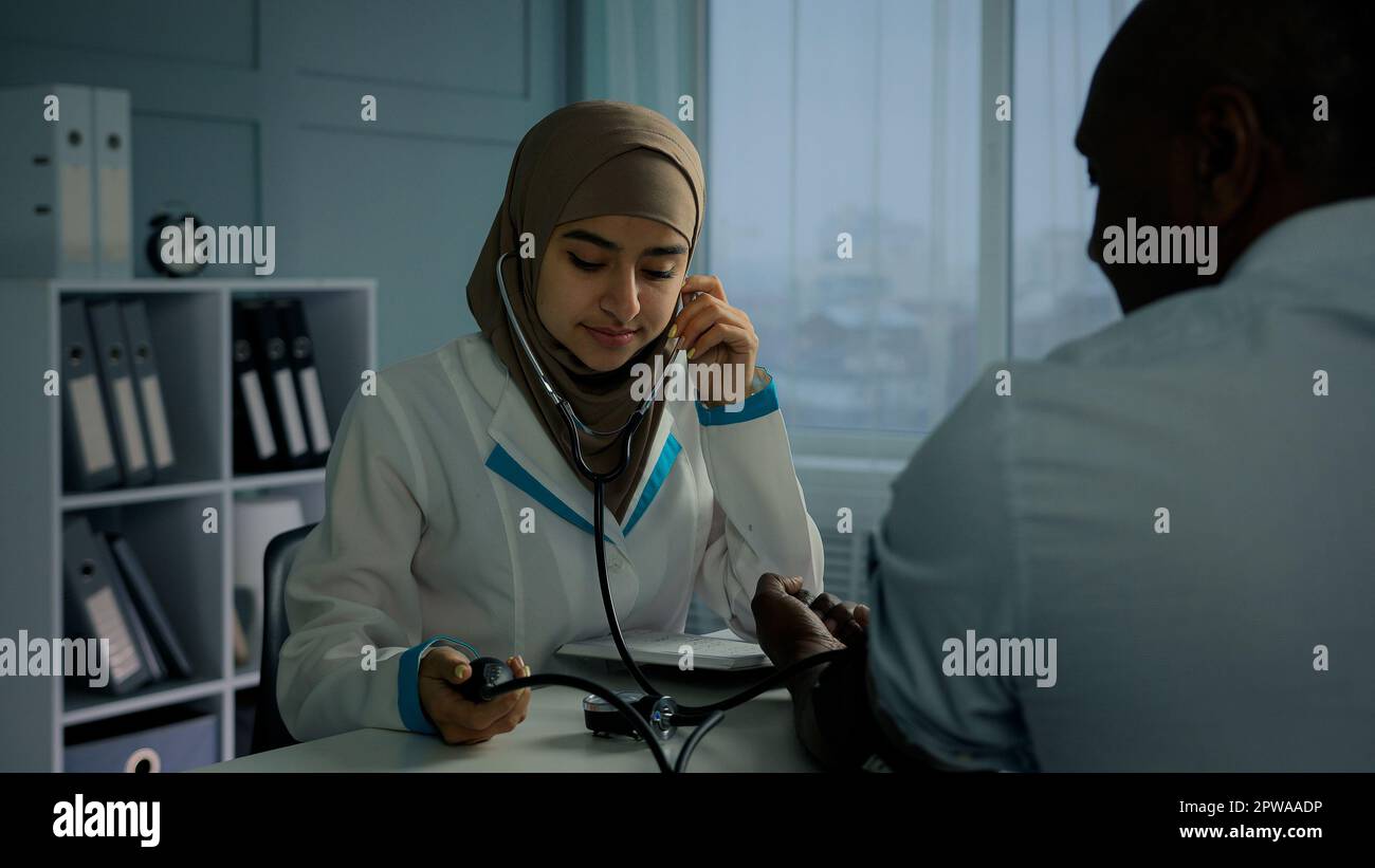 Doctor woman measuring blood pressure with electronic device use ...
