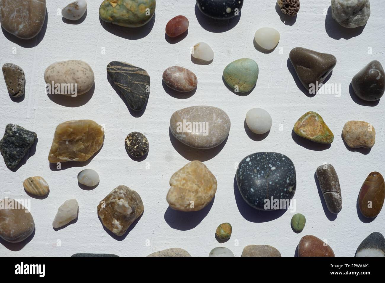 Pebble stones with diferent shapes and colors on white surface Stock ...