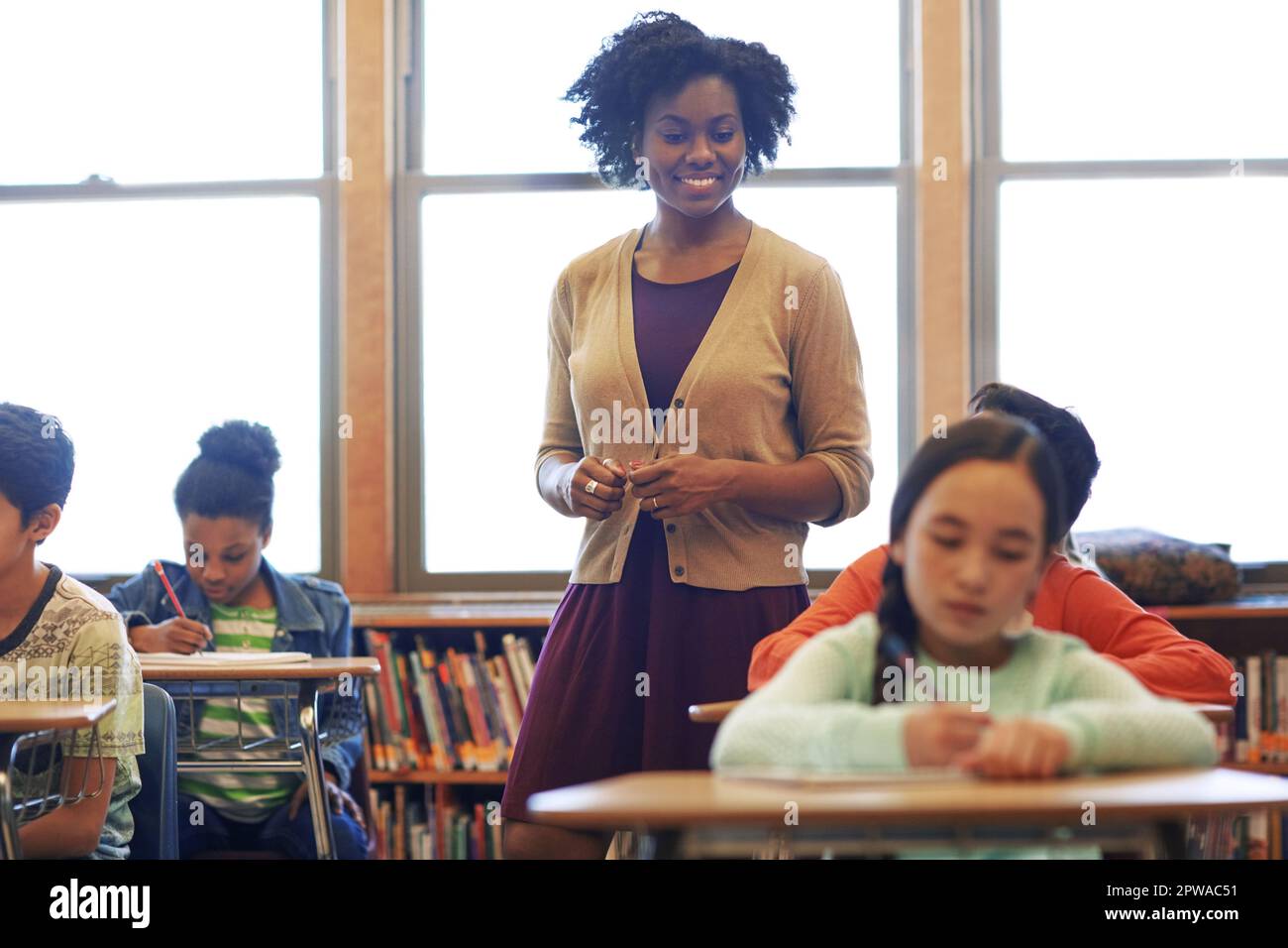 Shes a dedicated educator. a group of elementary children writing a ...
