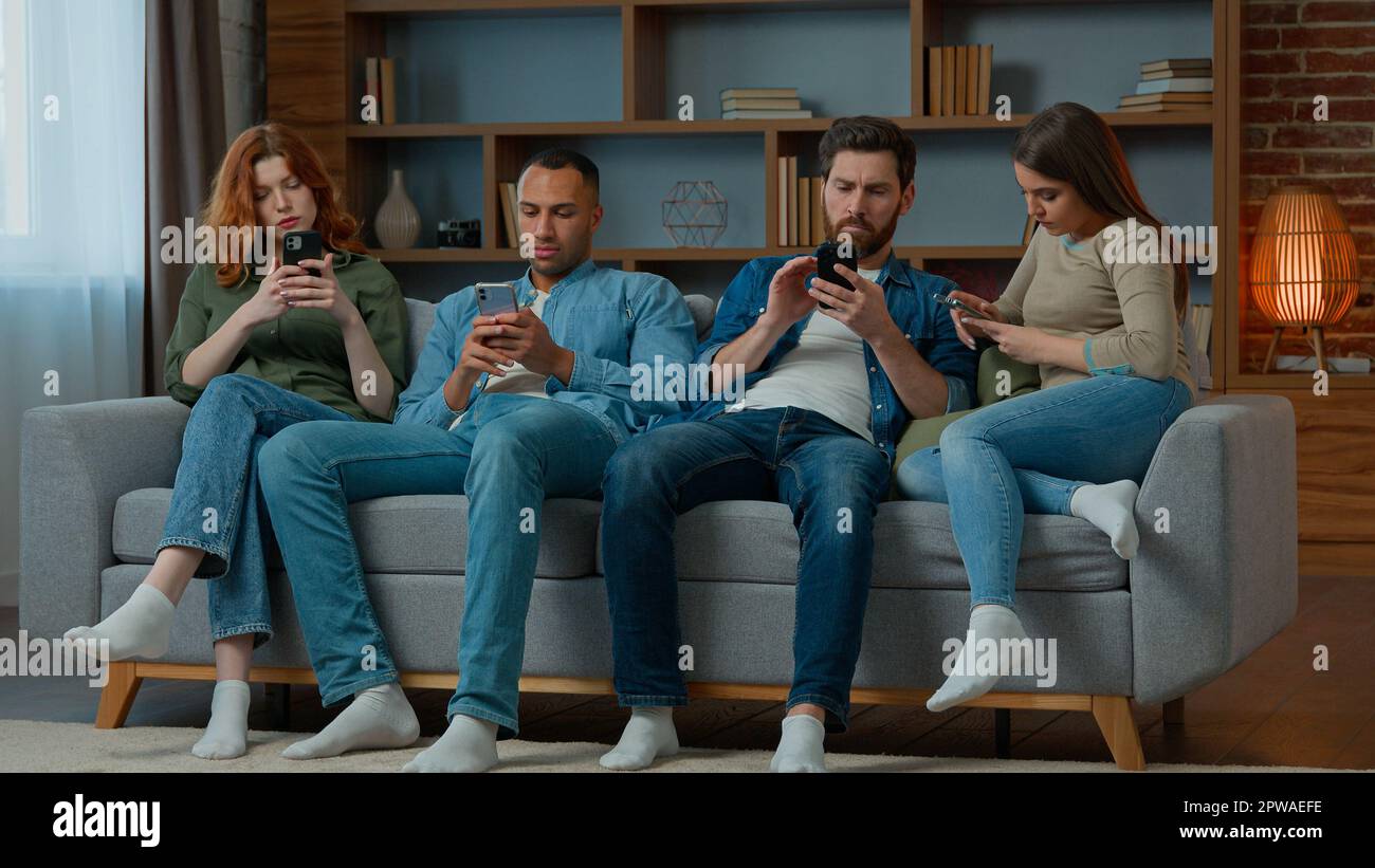Group friends business people sit on couch with mobile phones chatting ...