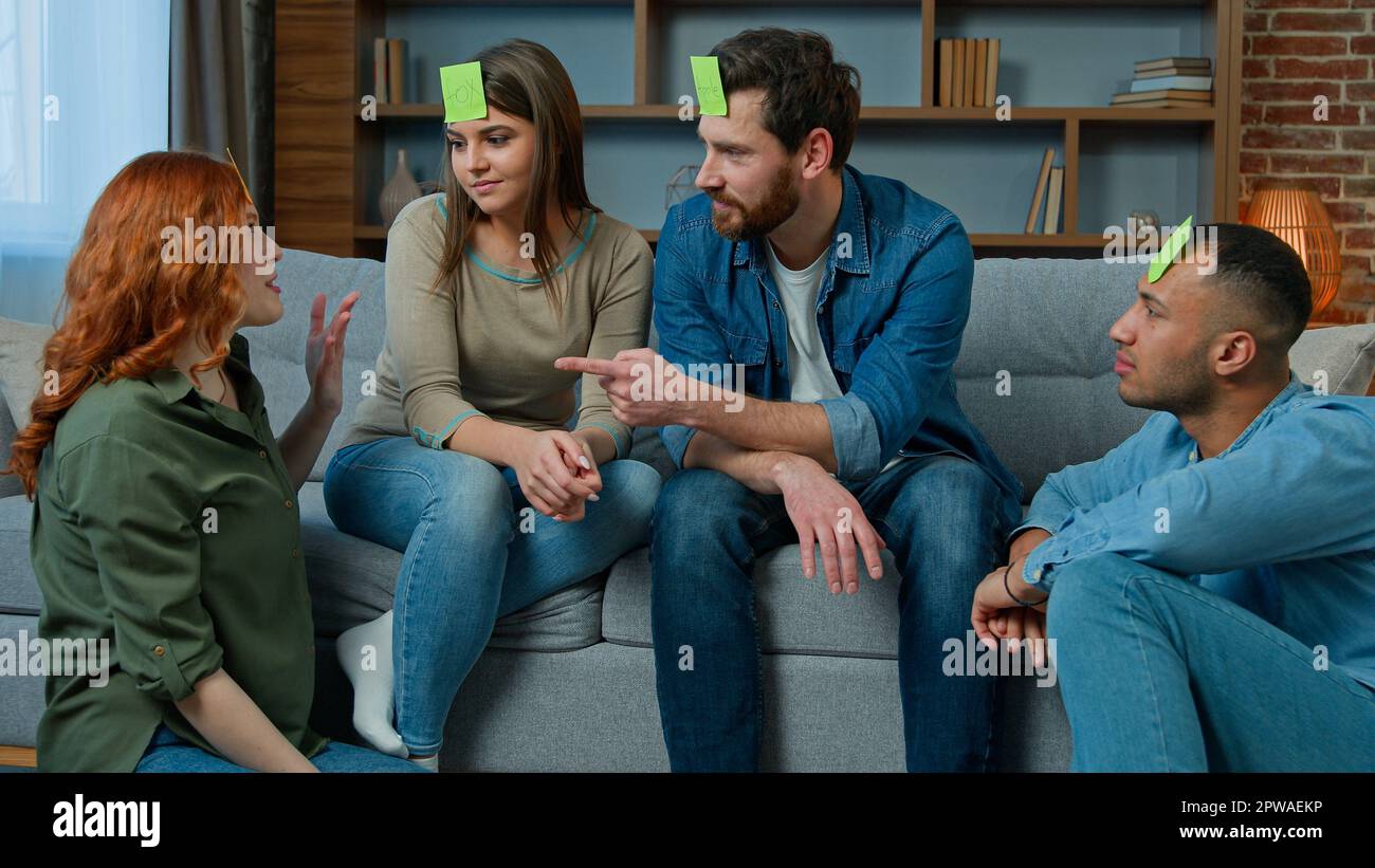 Group of multiethnic friends play charades game at home happy laughing ...
