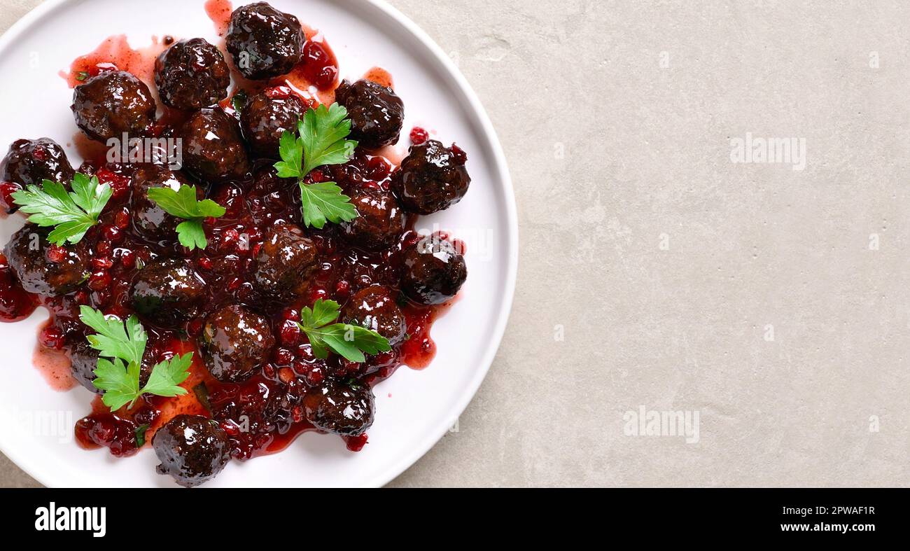 Close up view of meatballs with cranberry sauce on white plate over ...