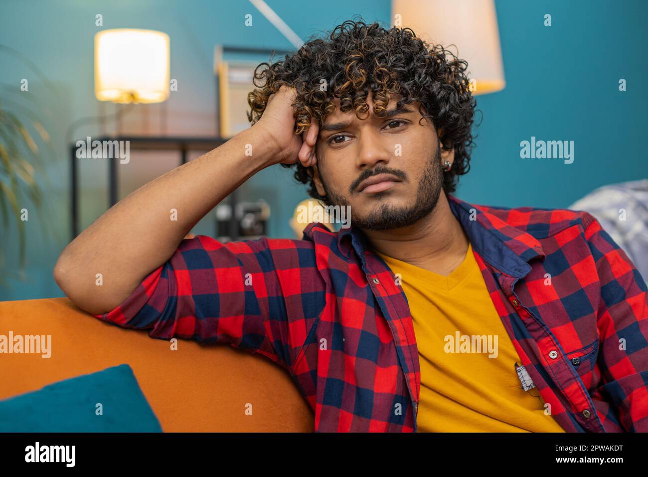 Sad lonely man sitting at home room looks pensive thinks over life ...