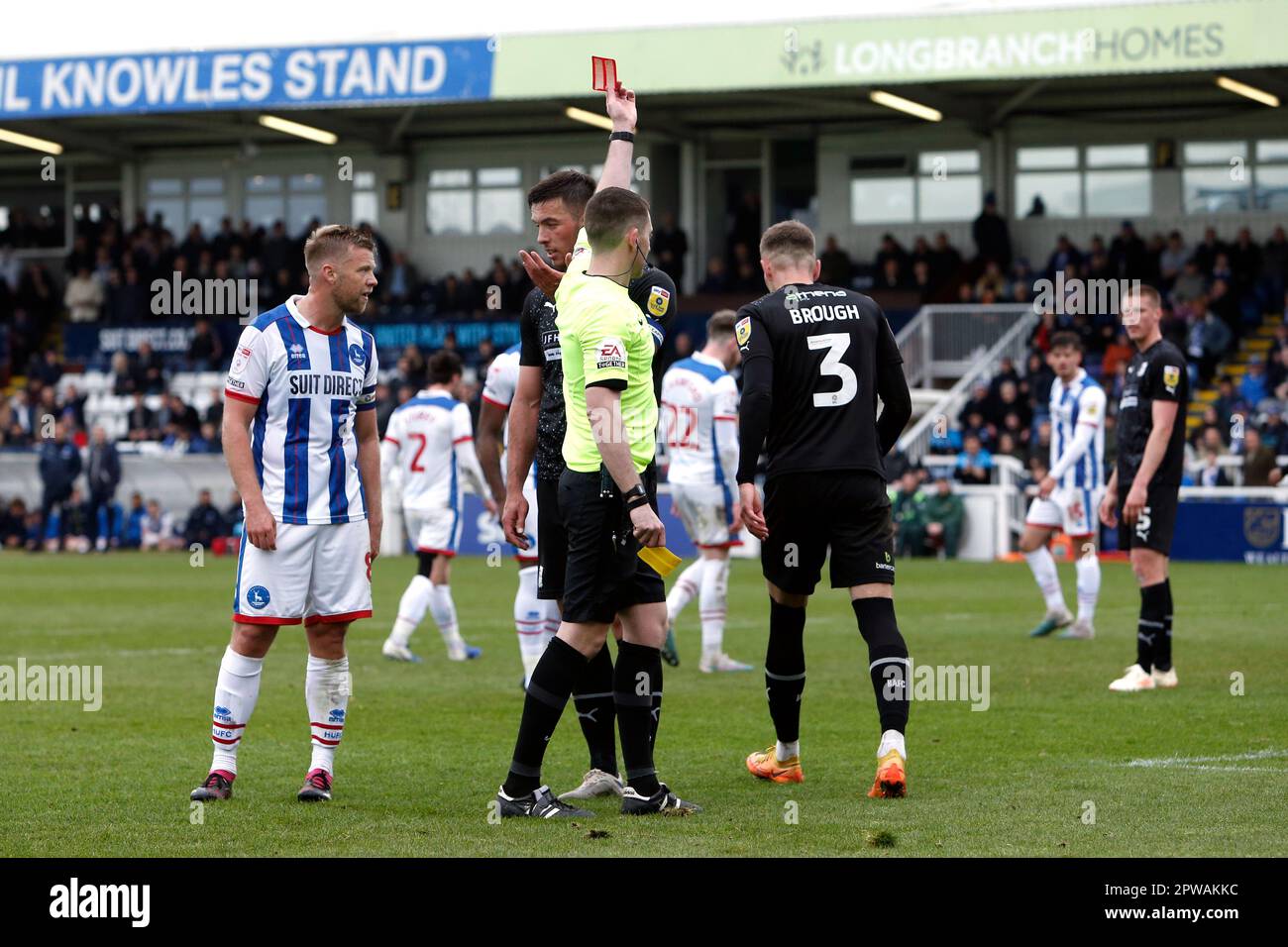 Barrow's Patrick Brough (right) is shown a red card by the referee ...