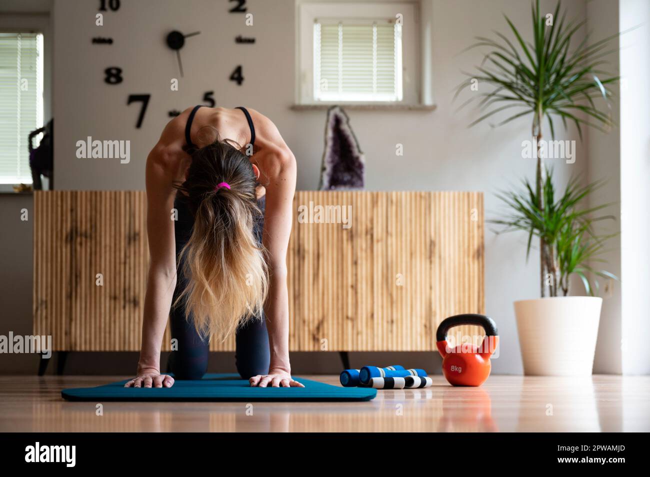 Front view of a slim fit young woman practicing yoga or pilates routine ...