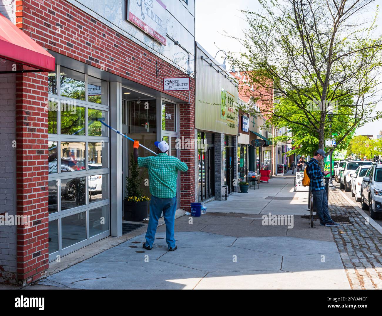 A man washing windows at a store on Forbes Avenue in the Squirrel Hill ...