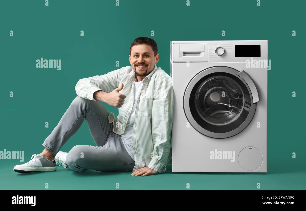 Handsome man with big blank poster showing thumb-up on green background ...