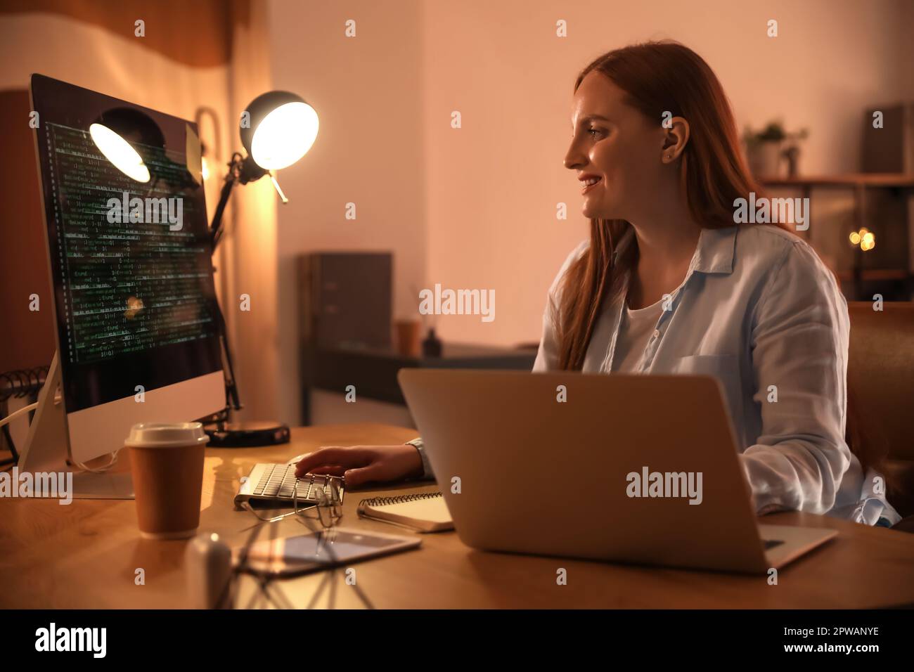 Female programmer working with computer in office at night Stock Photo ...