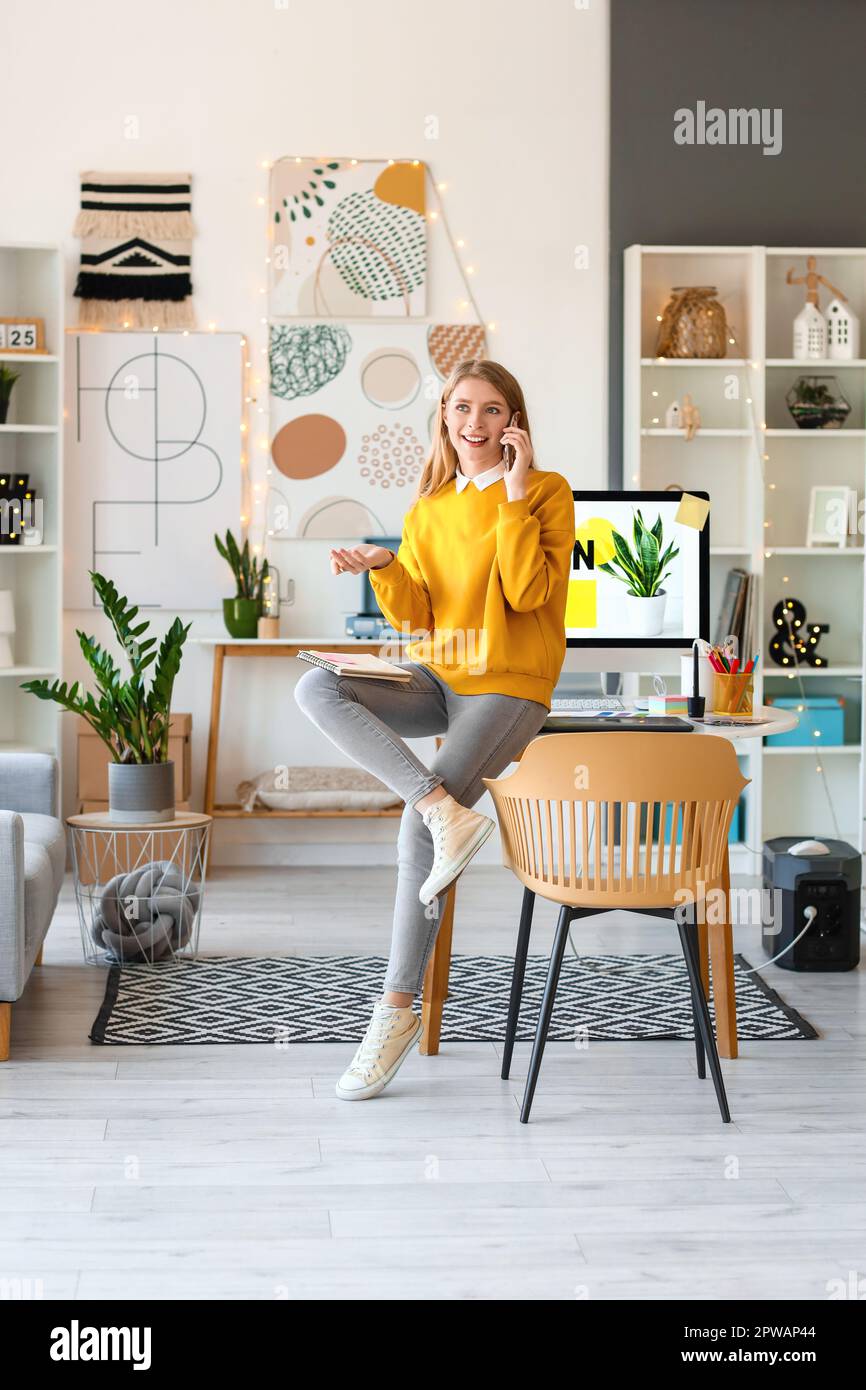 Female graphic designer talking by mobile phone in office Stock Photo ...
