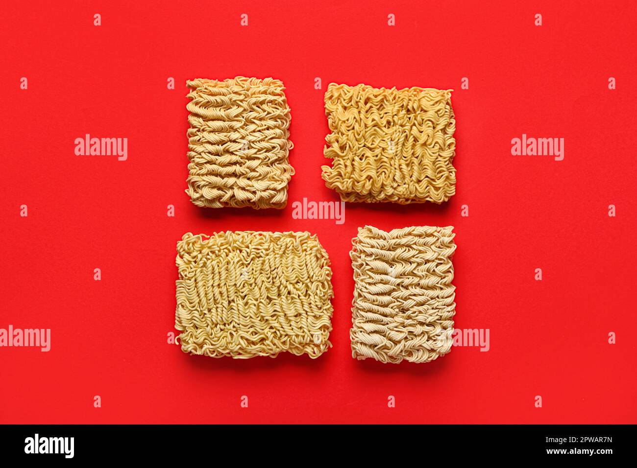 Raw instant noodles on red background Stock Photo - Alamy