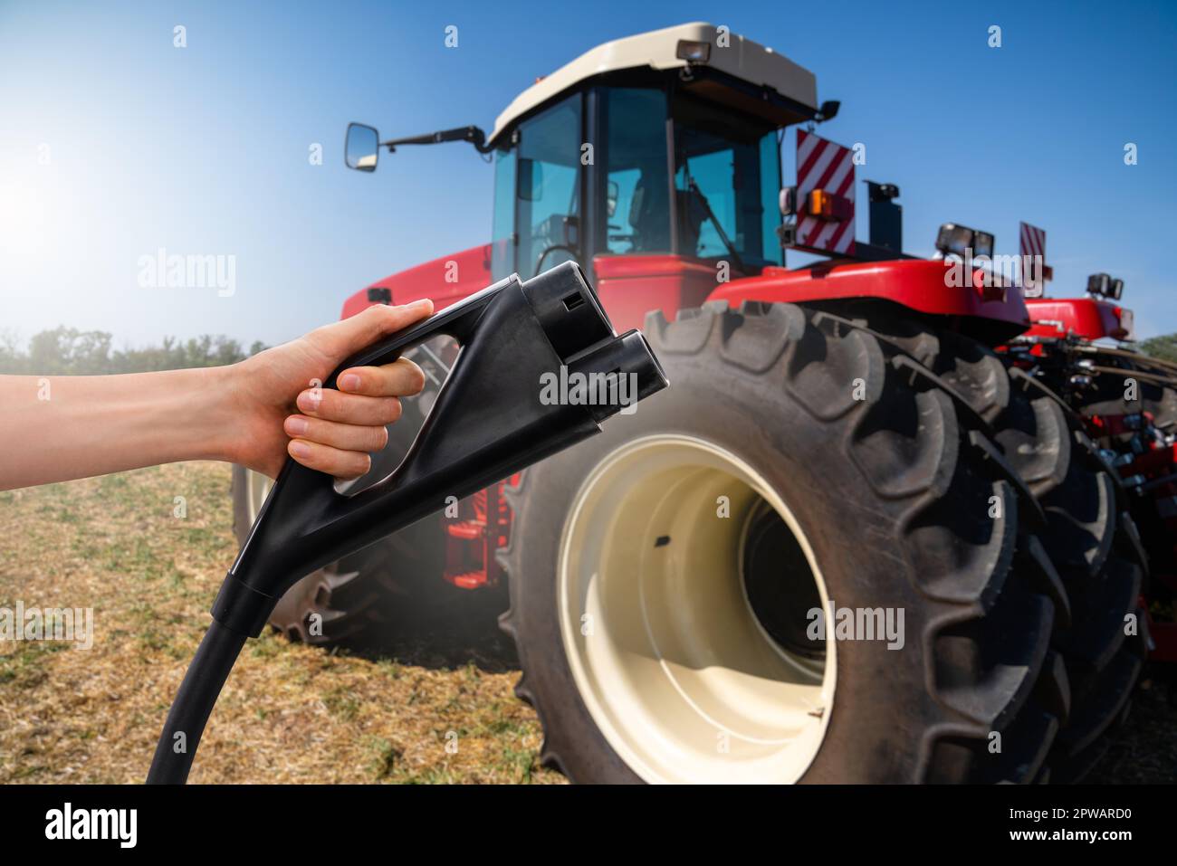 Hand with electric vehicles charging plug on a background of ...