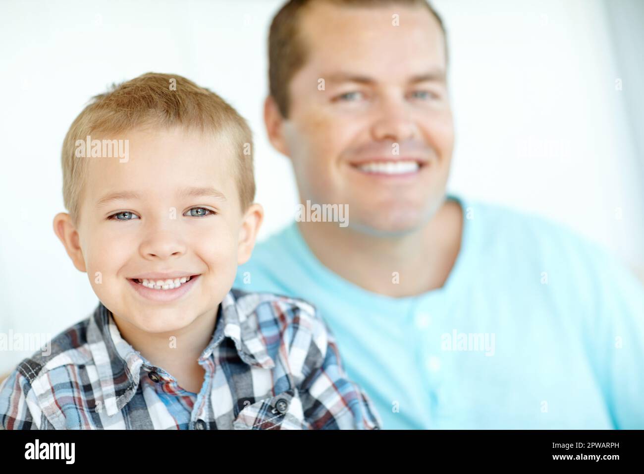 Dad and his little boy. Cropped portrait of a cute young boy sitting ...
