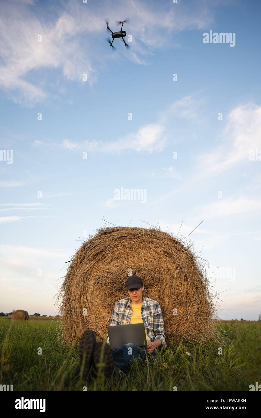 Farmer with laptop and drone on the field. Smart farming and ...