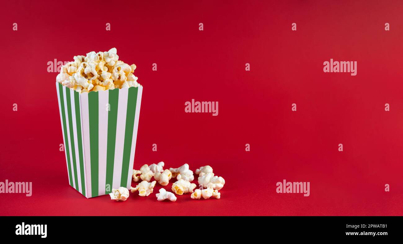 Green white striped carton bucket with tasty cheese popcorn, isolated ...