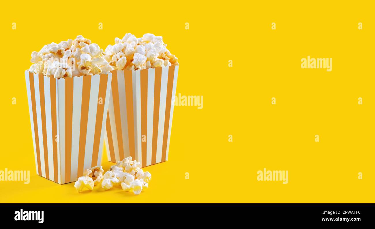 Two orange white striped carton buckets with tasty cheese popcorn ...