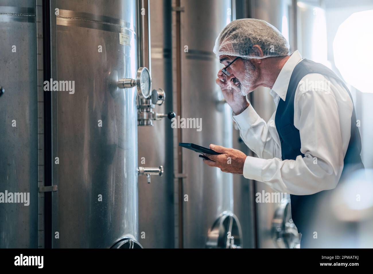Winemaker working in modern large winery factory liquor drink industry ...