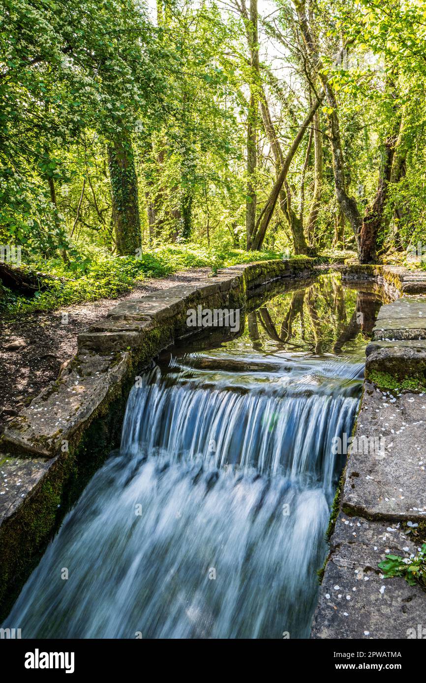Small stream cascading down man-made overflow for a canal in Wales ...