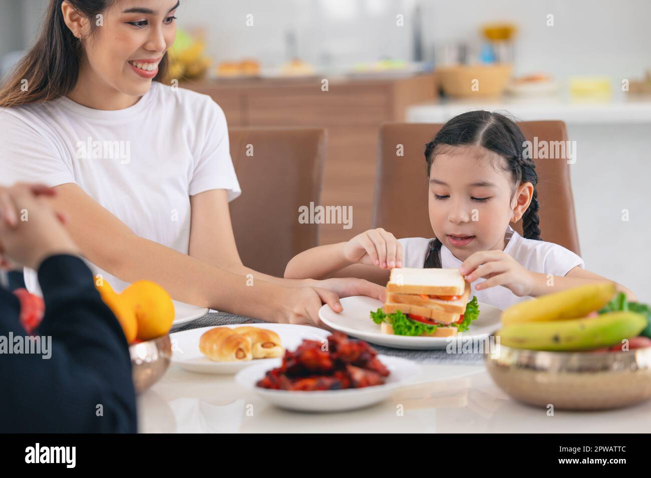 Asian cute daughter happy enjoy eating healthy food morning meal ...
