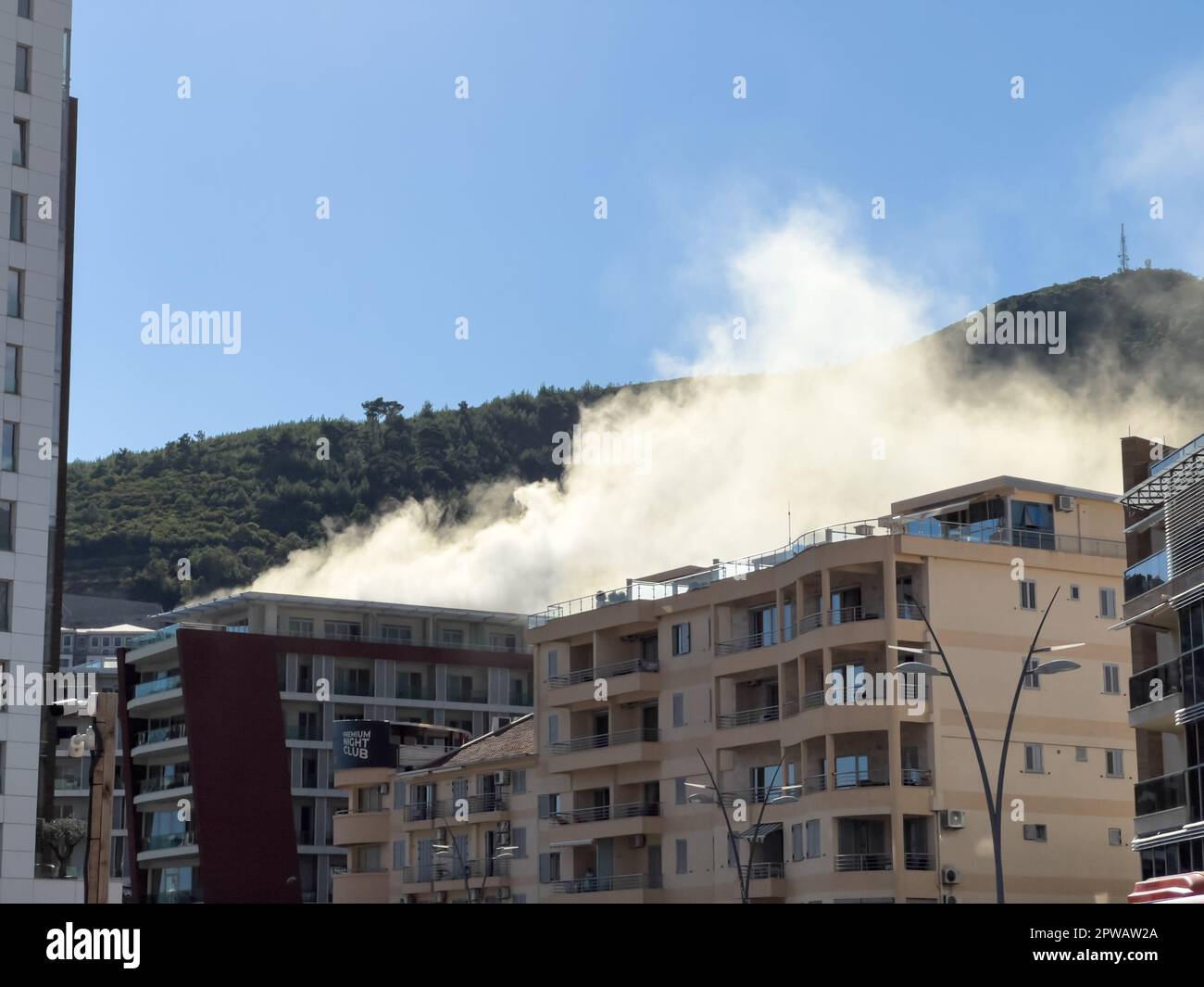 White smoke from a burning high-rise building against the backdrop of ...