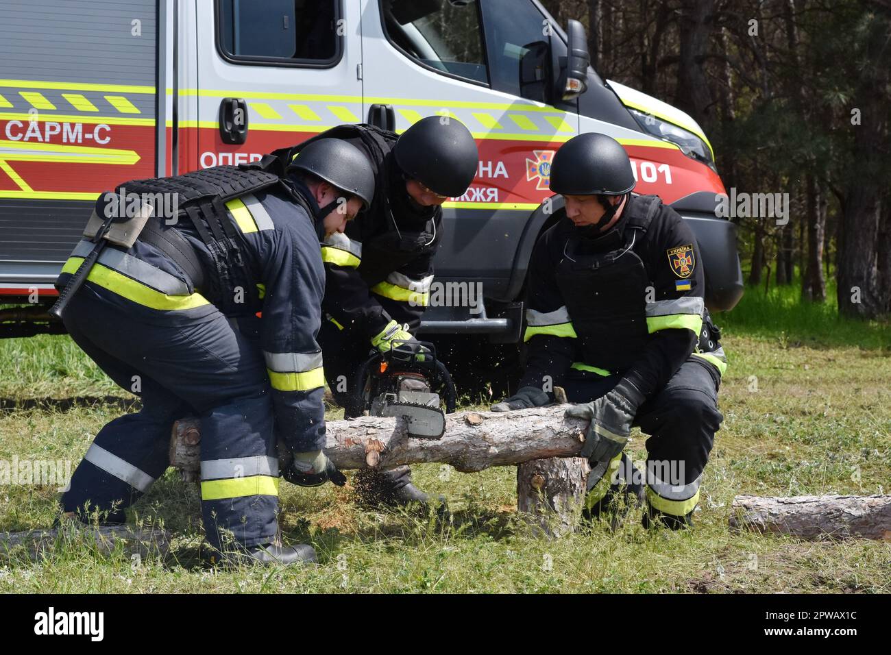 Members of the Ukrainian State Emergency Service seen cutting wood ...