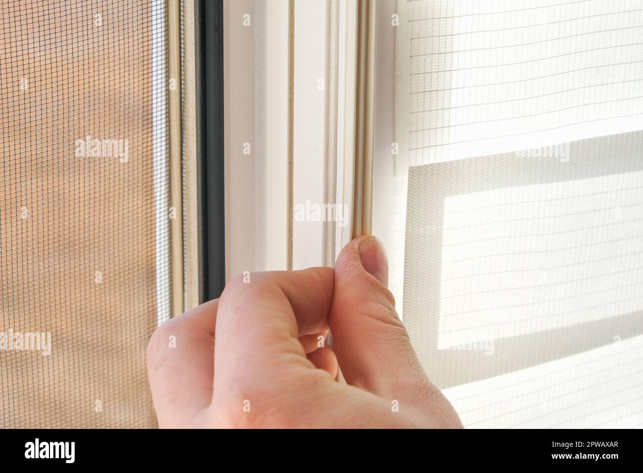 The man wipes the window frame with a degreaser and glues a sealing ...