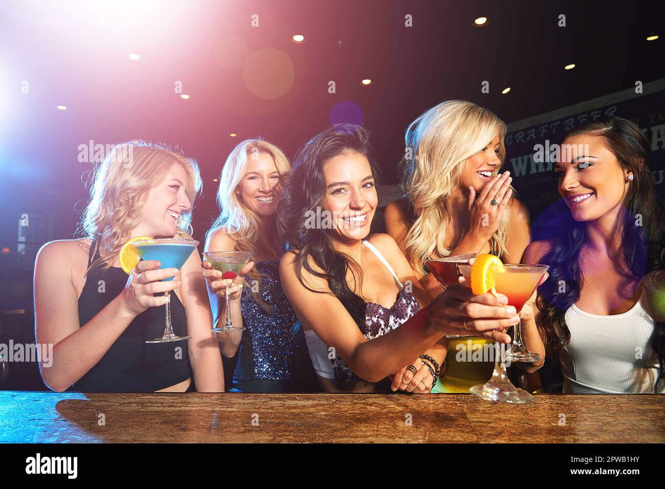 The girls are having fun tonight. young women drinking cocktails in a ...