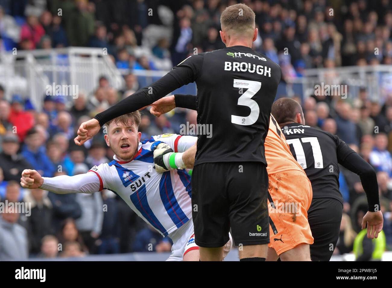 Hartlepool United's Tom Crawford falls to the flat after being pushed over by Barrow's Paul ...
