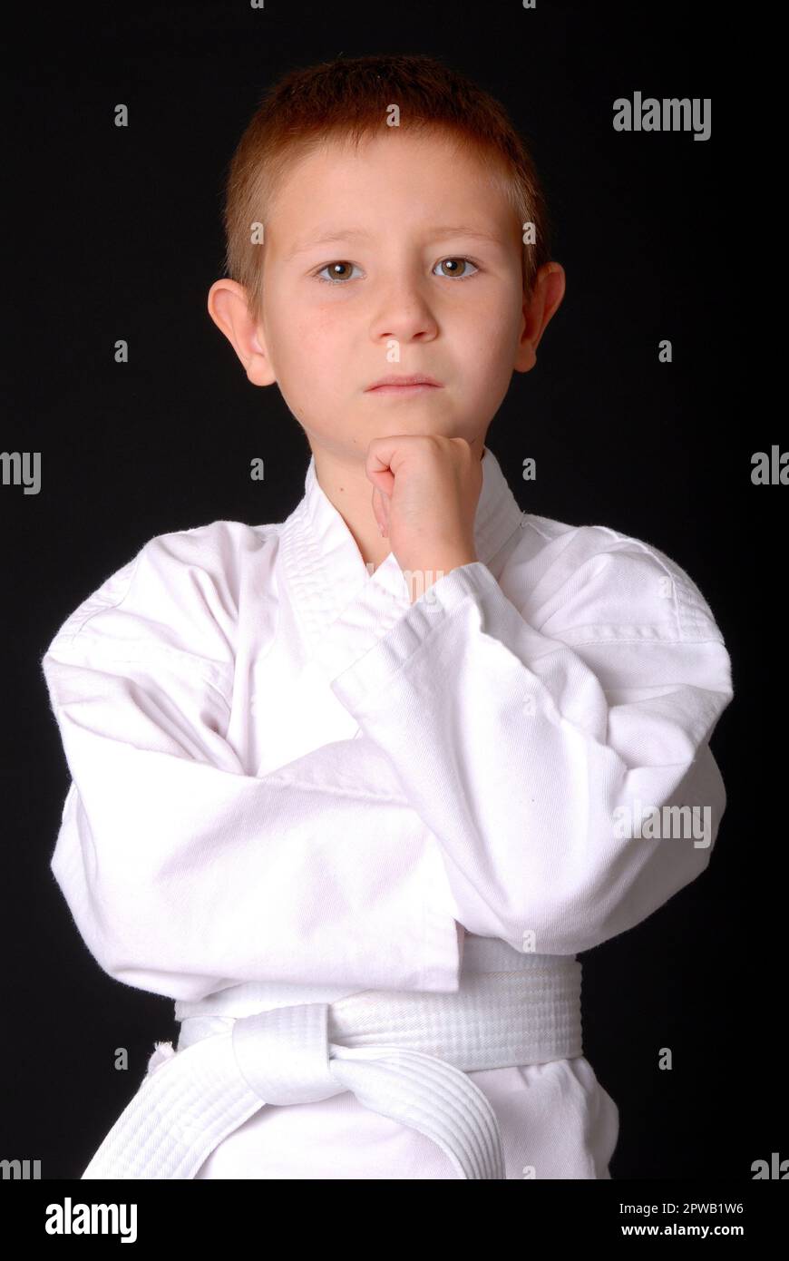 Young boy in karate outfit appearing thoughtful Stock Photo - Alamy