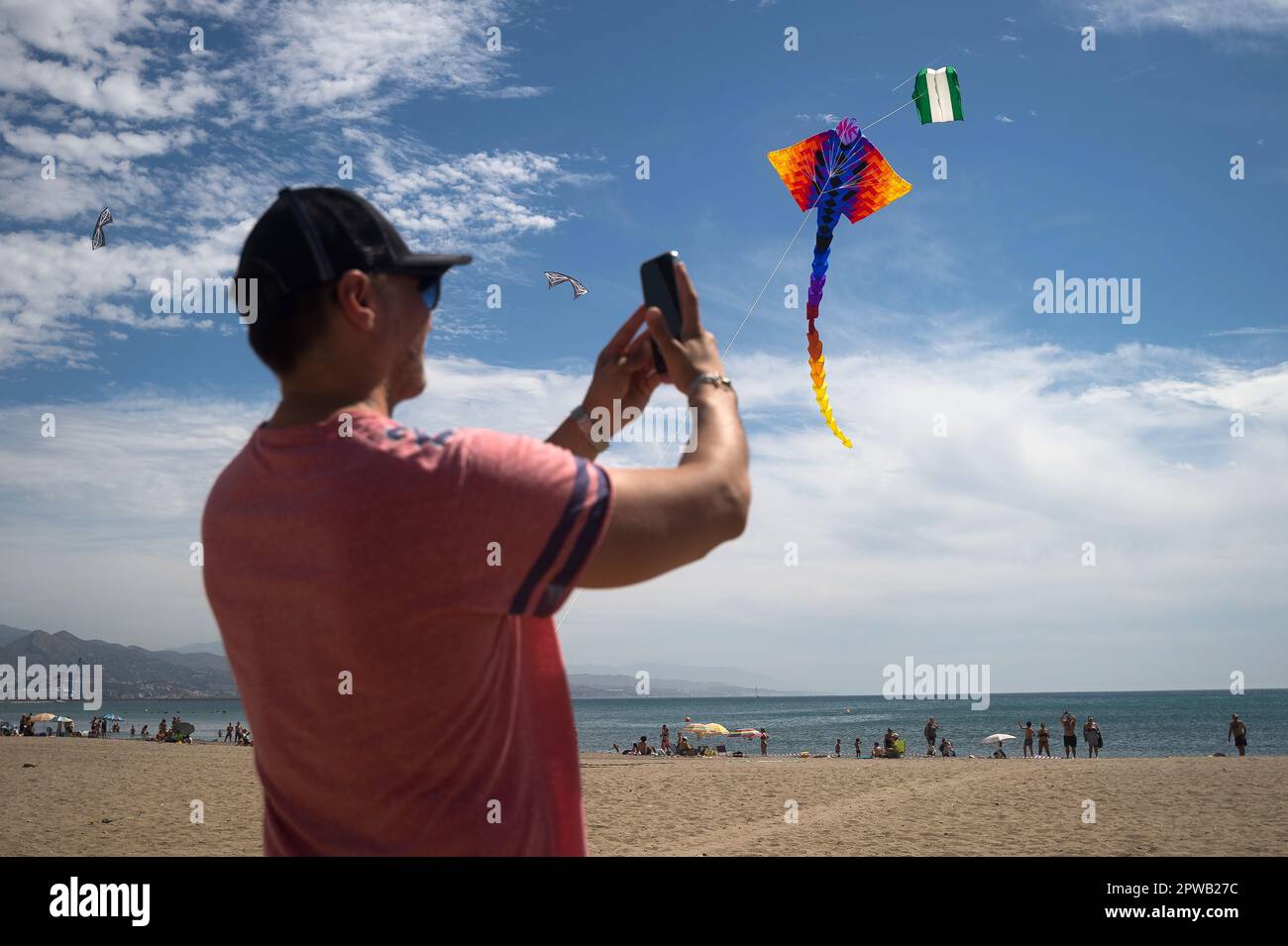 Malaga, Spain. 29th Apr, 2023. A man takes pictures of a kite floating ...
