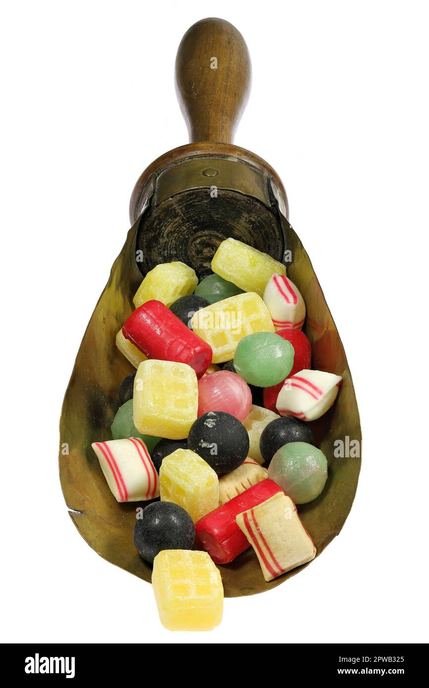 classic Dutch candies in a vintage brass weighing scoop isolated on ...