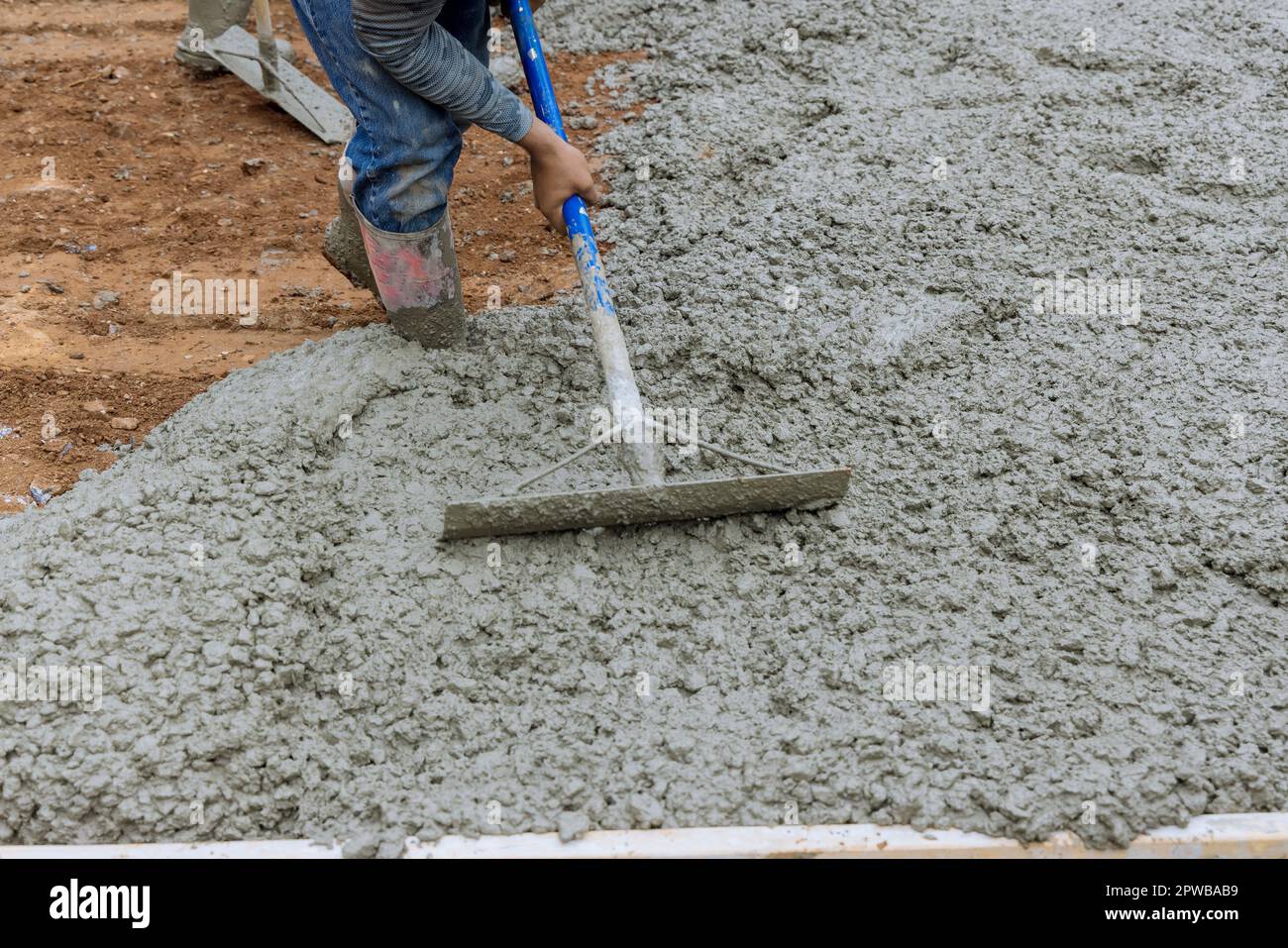Concrete driveways for car parking are poured by worker at the ...