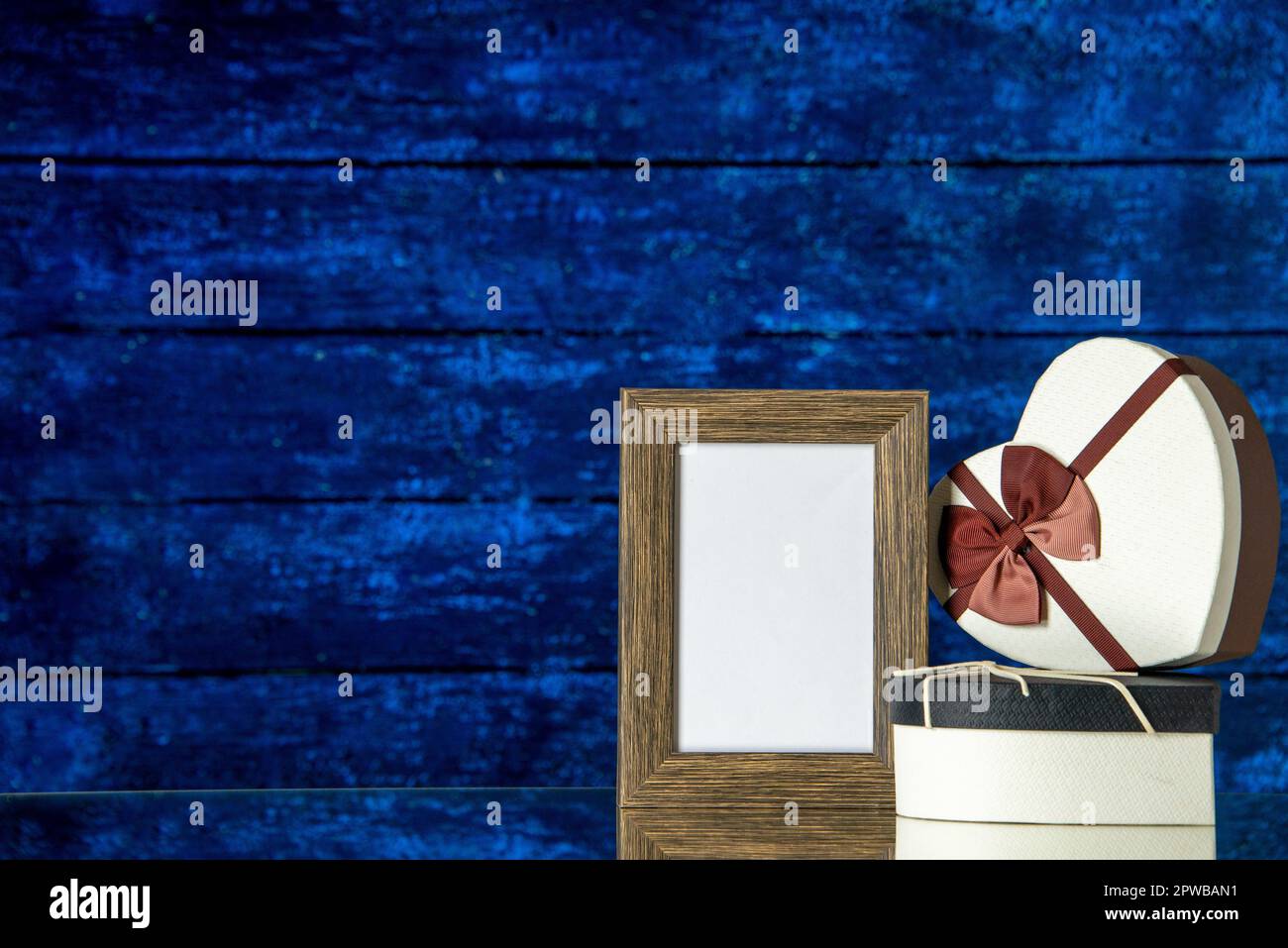 front view valentines day presents with picture frame on the dark blue ...