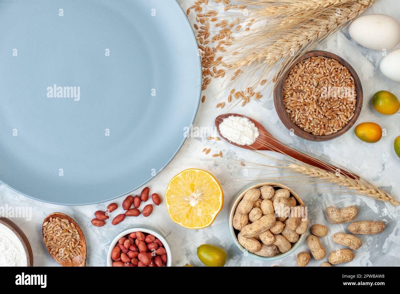 top view blue plate with flour jelly eggs and different nuts on a white ...