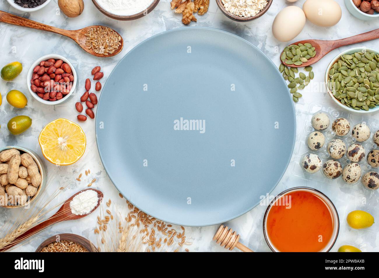 top view blue plate with flour jelly eggs and different nuts on white ...
