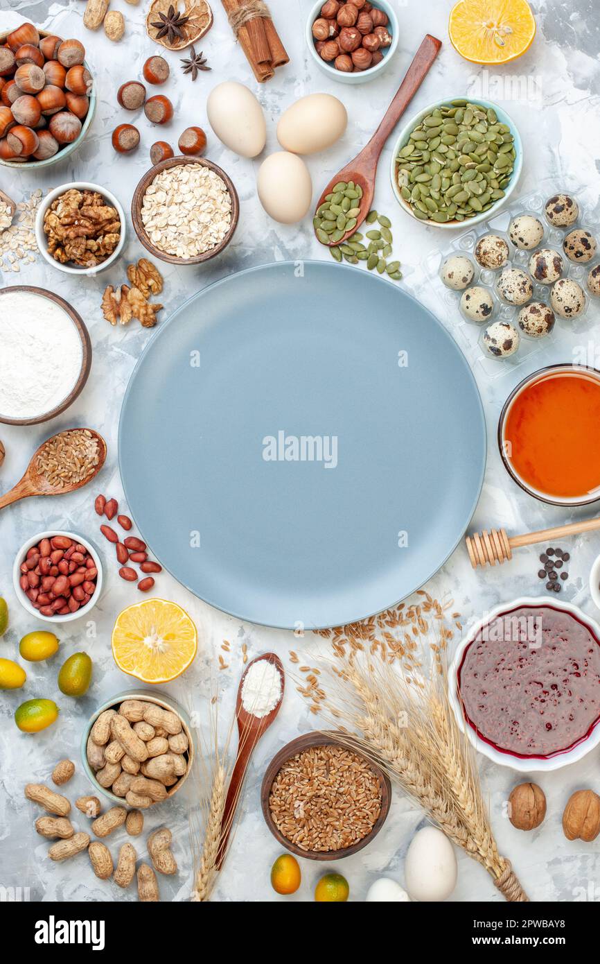 top view blue plate with flour jelly eggs and different nuts on white ...