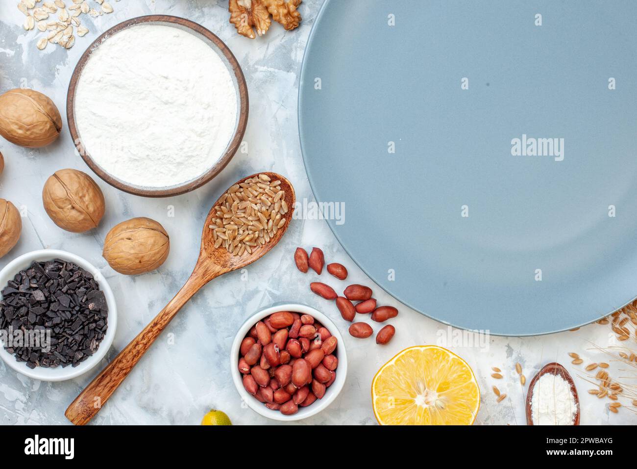 top view blue plate with flour jelly eggs and different nuts on white ...