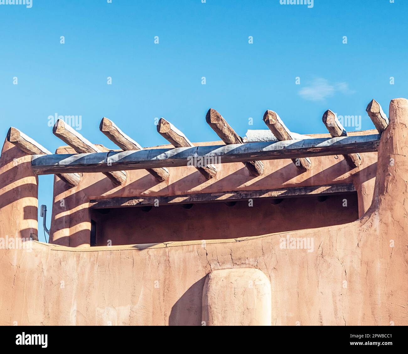 A horizontal minimalist composition of a beige adobe building with ...