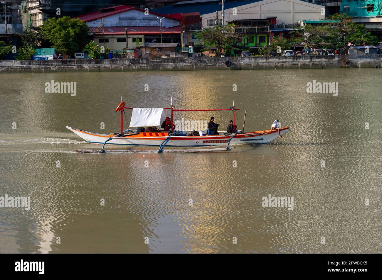 A small boat sailing down the Pasig River, Manila, The Philippines ...