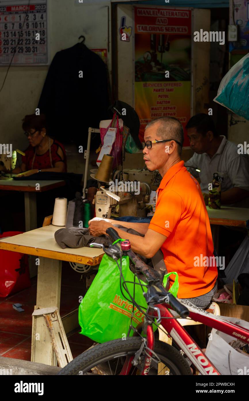 Filipino tailors working hard altering clothes, Manila, The Philippines ...
