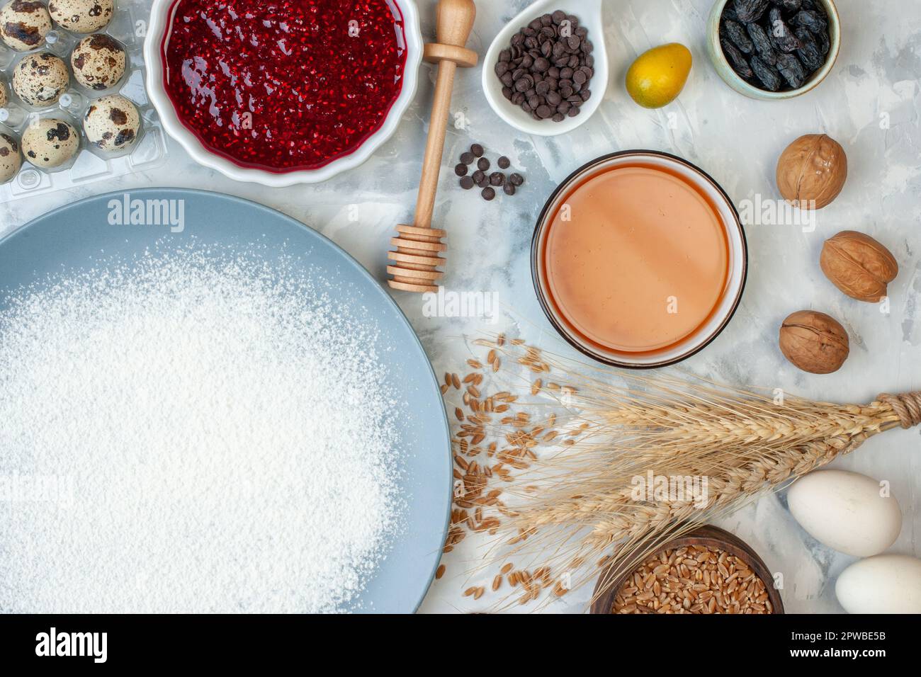 top view white flour inside plate with nuts seeds and eggs on white ...