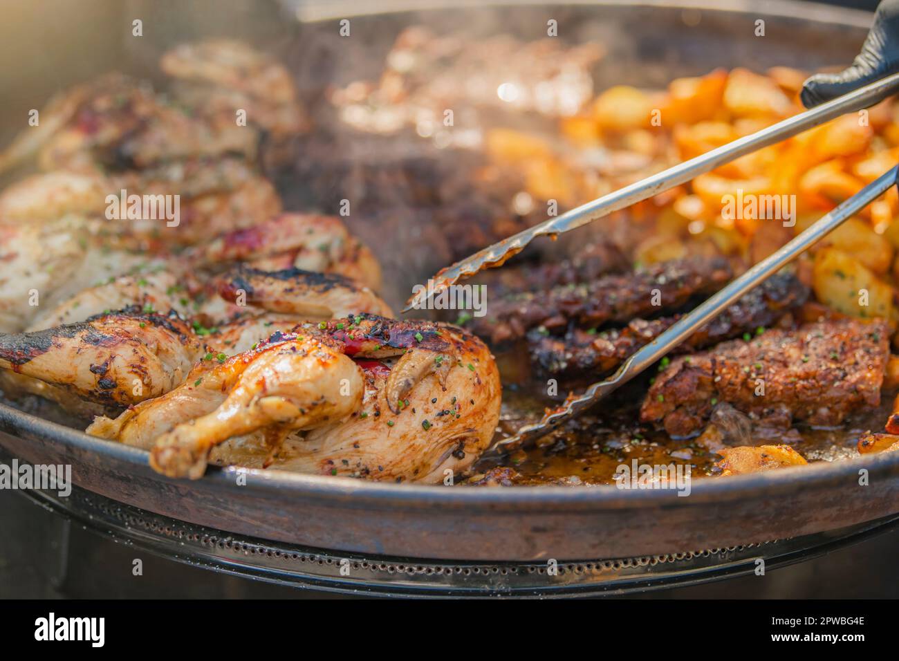 Fast food cooking process. A man flips food in a large pan for a town ...