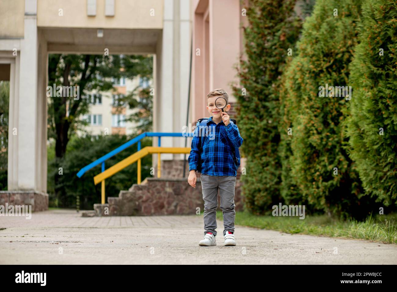 Schoolboy looking through a magnifying glass, with a surprised ...