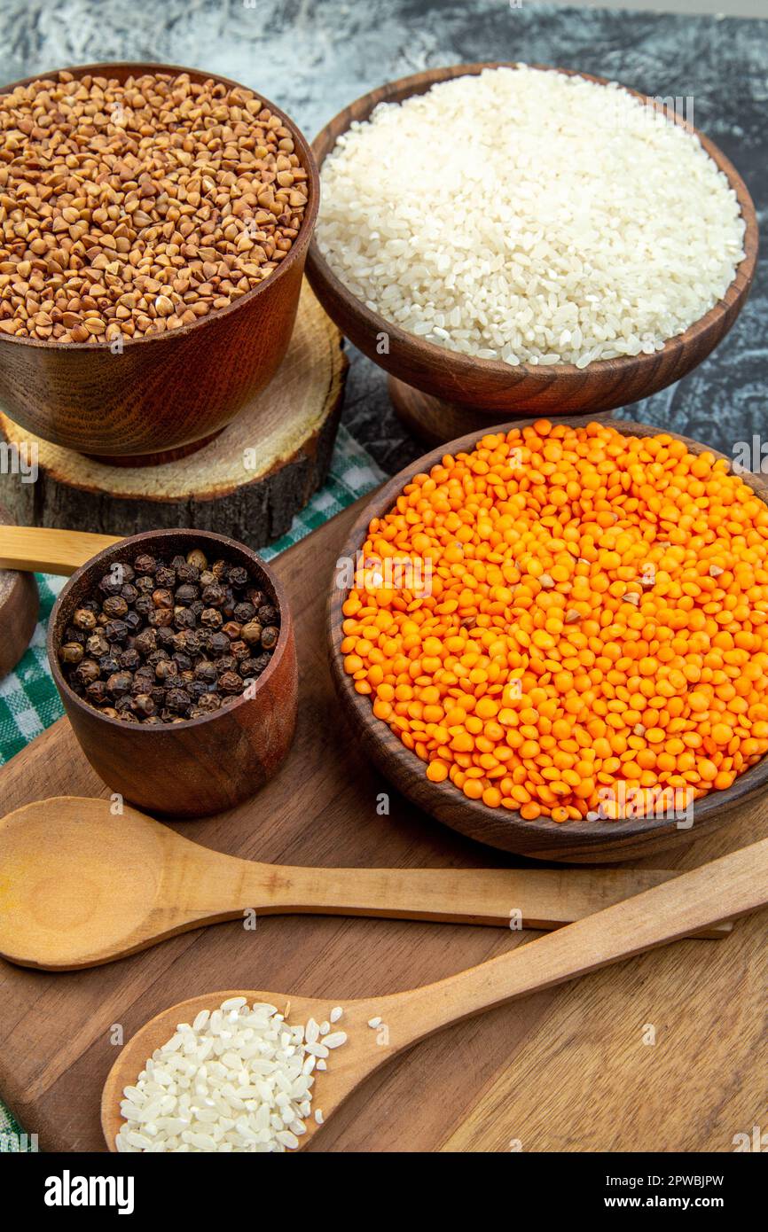 front view raw rice with orange lentils and buckwheat on dark ...