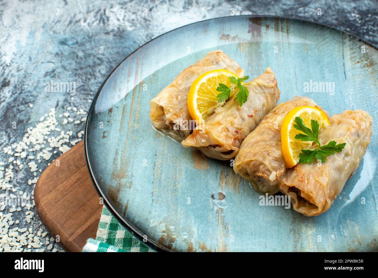front view tasty cabbage dolma with lemon slices and seasonings on gray ...