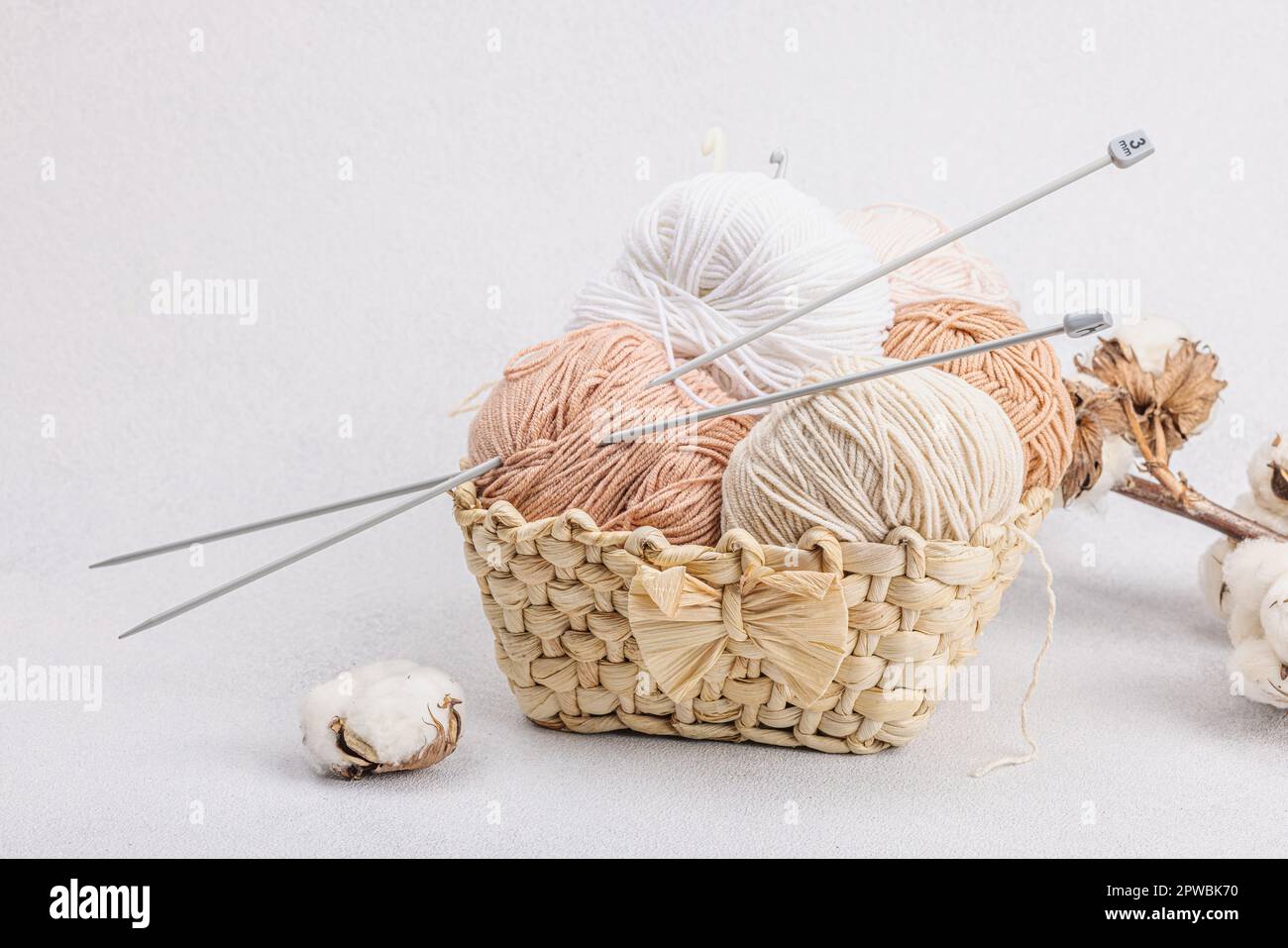 A set of pastel clew of thread for knitting in a basket. Handmade ...