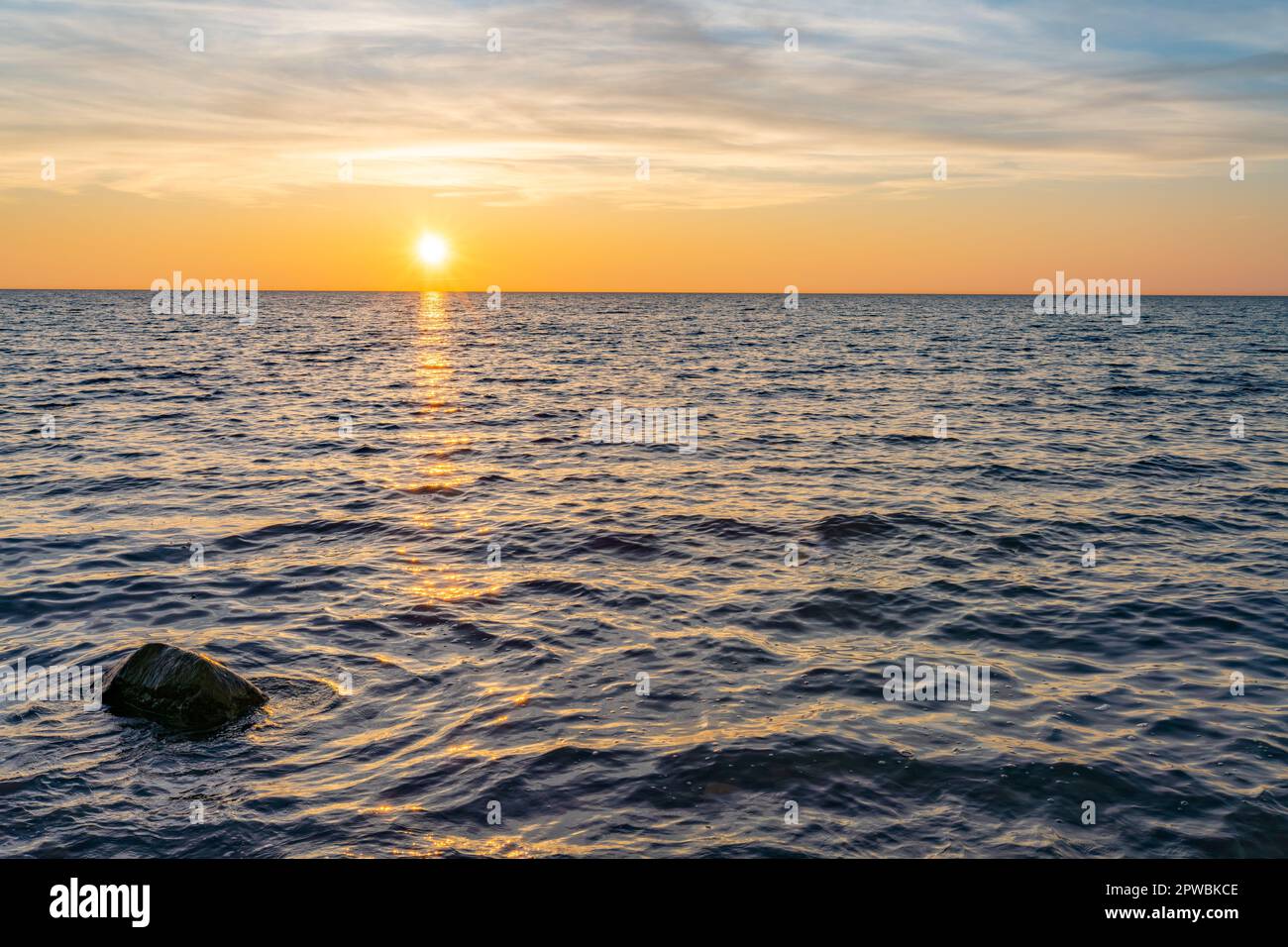 dreamlike, orange, sunset between rocks in the sea of the Baltic Sea ...