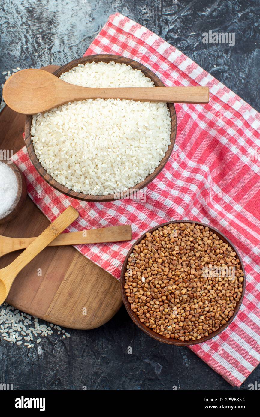 top view raw rice with orange lentils and buckwheat on dark background ...