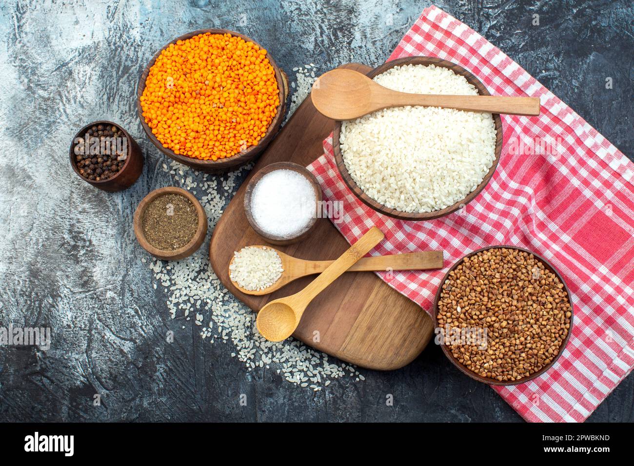 top view raw rice with orange lentils and buckwheat on dark background ...