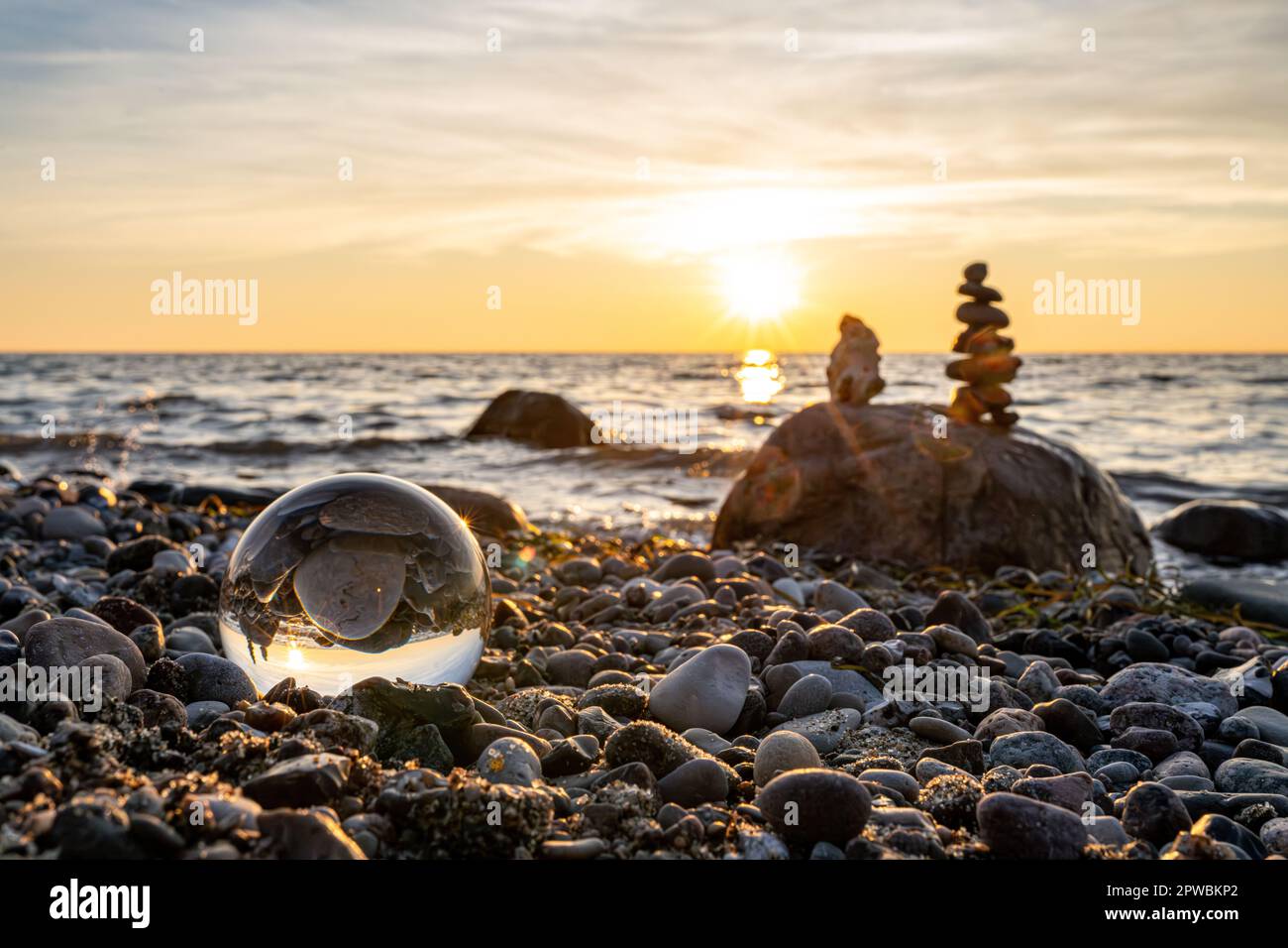 Stone pyramids and glass sphere on the dreamy Baltic Sea sand beach on ...