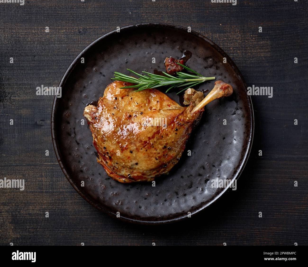 plate of duck leg confit on black table, top view Stock Photo - Alamy
